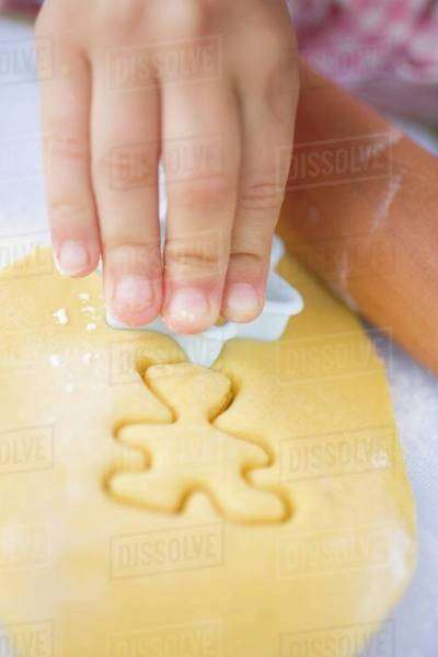 Child cutting out a biscuit - Stock Photo - Dissolve