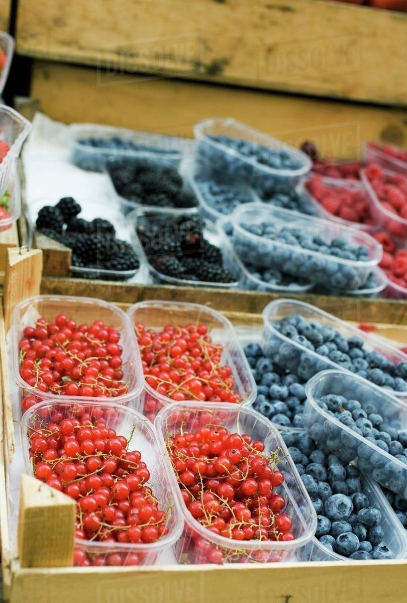 Various types of berries in plastic punnets at a market - Royalty-free ...