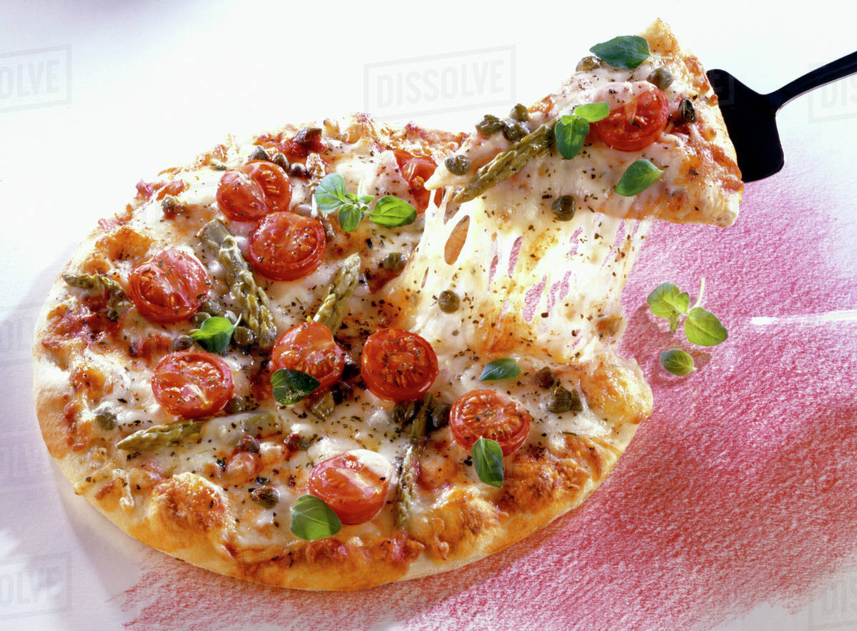 Piece of pizza pulling strands of cheese from vegetable pizza - Royalty ...