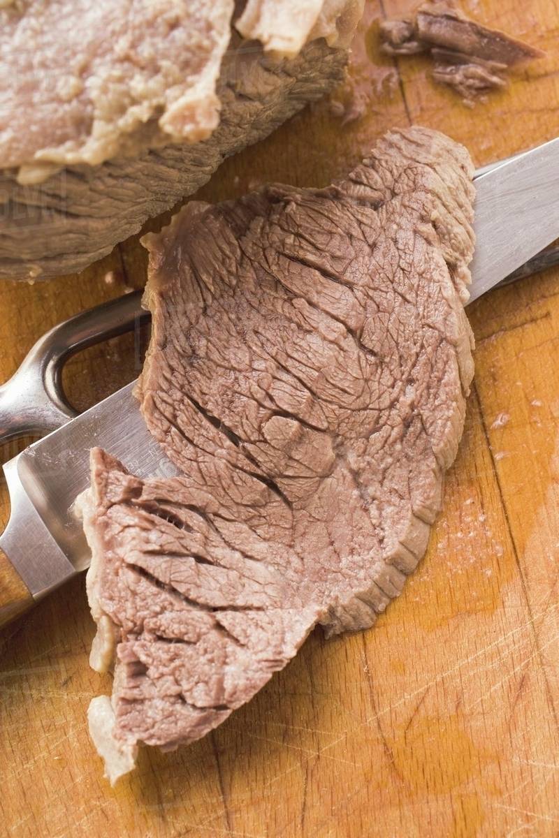 Boiled beef with a slice carved - Royalty-free Stock Photo | Dissolve