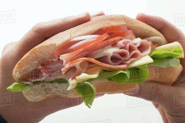 Hands holding ham and cheese sub sandwich - Royalty-free Stock Photo ...