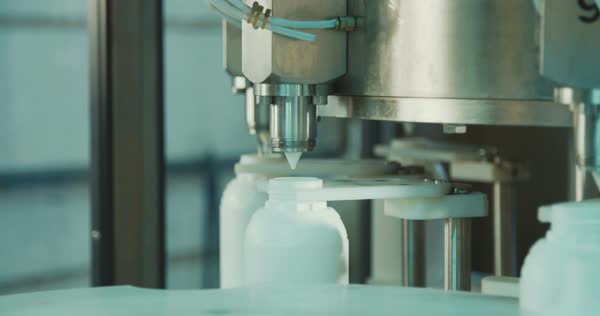 Machine filling bottles with chemicals in a production line - Stock ...