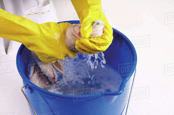 Woman wringing out cleaning rag, elevated view - Stock Photo - Dissolve
