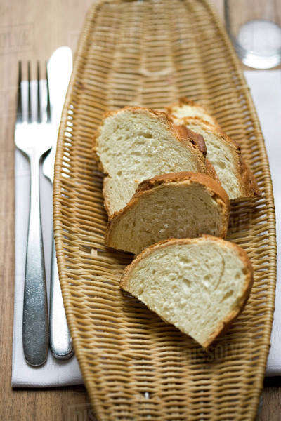 Slices of bread on tray at table, elevated view - Stock Photo - Dissolve