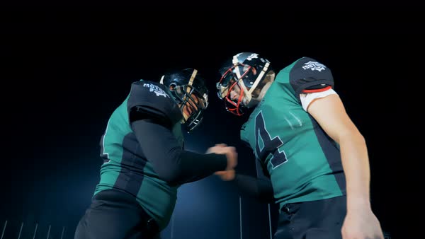 Two american football players shaking hands before a game, close up ...