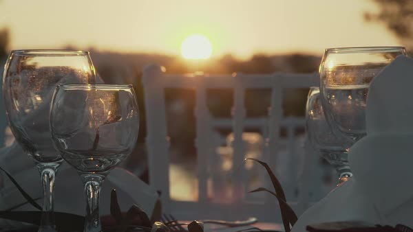 A dinner table at a sea restaurant in sunset background on a summer day ...