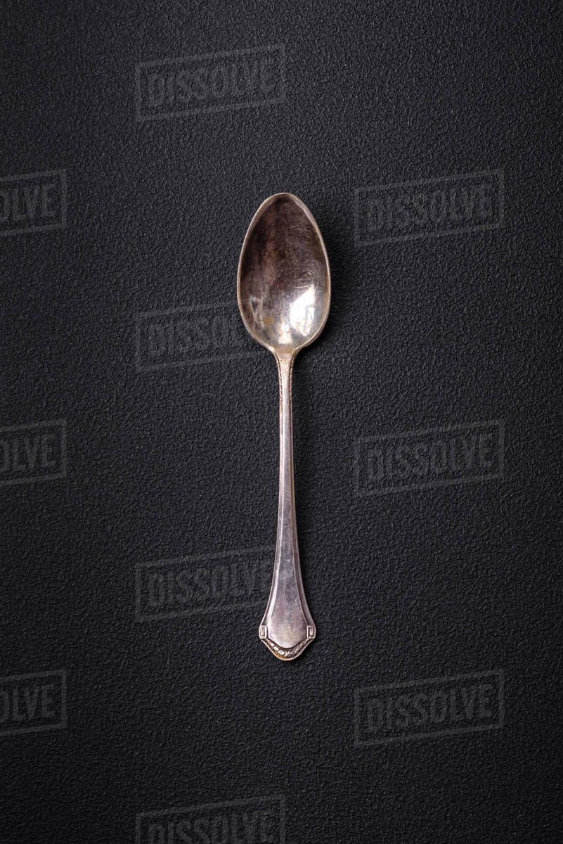 Empty metal spoon on dark textured concrete background. Cutlery ...