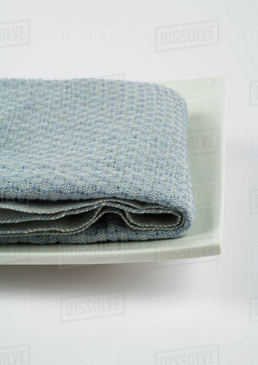 Towel folded on square dish - Stock Photo - Dissolve