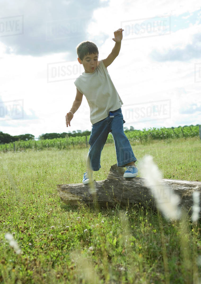 Boy standing on log - Royalty-free Stock Photo | Dissolve