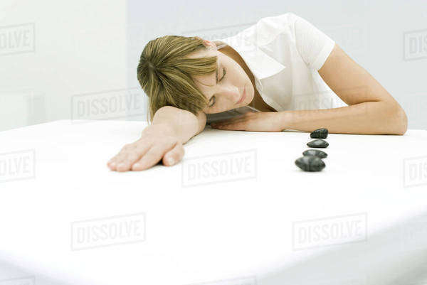 Woman resting head on table beside lined up stones - Royalty-free Stock ...