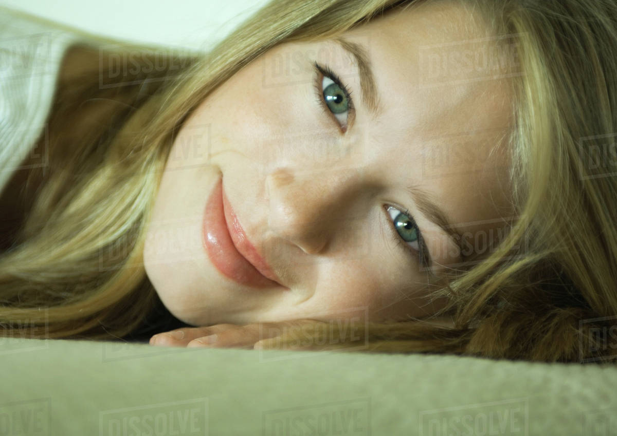 Young woman resting head on hand, smiling, close-up - Royalty-free ...