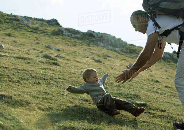 Boy falling as father reaches for him - Stock Photo - Dissolve