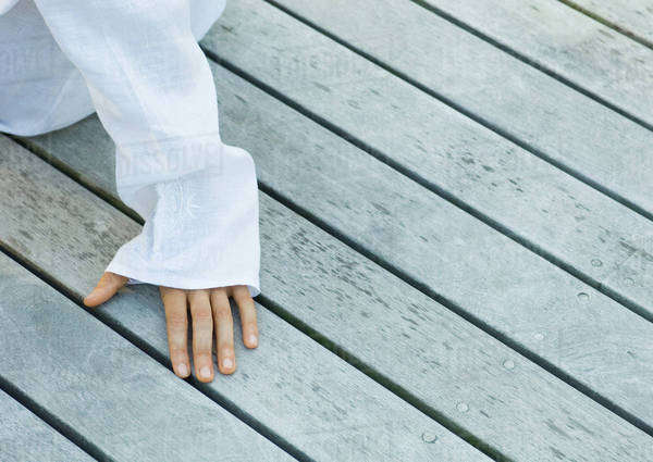 Hand on decking, cropped view - Royalty-free Stock Photo | Dissolve