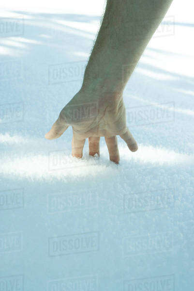 Man's hand touching snow - Royalty-free Stock Photo | Dissolve