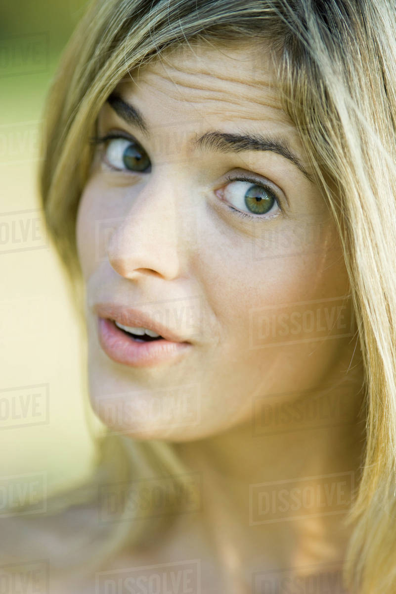 Young woman giving sideways glance at camera, portrait, close-up ...