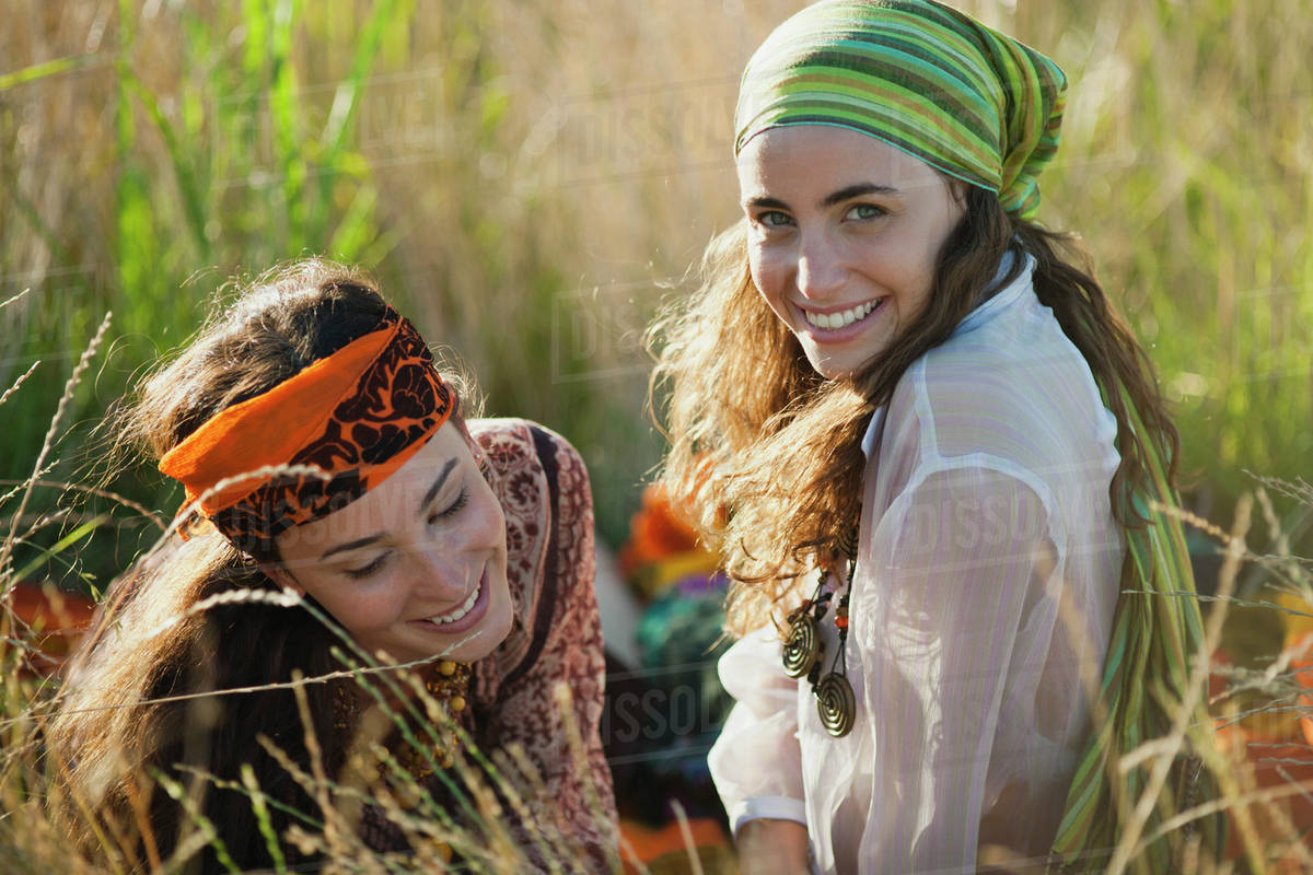 Young women reclining in grass together - Stock Photo - Dissolve
