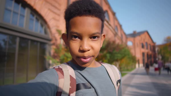 African-American school kid talking and looking at camera. Realtime ...