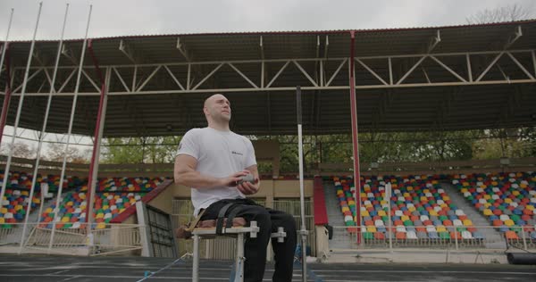 Adult handicapped male athlete grasping pole and throwing ball during ...