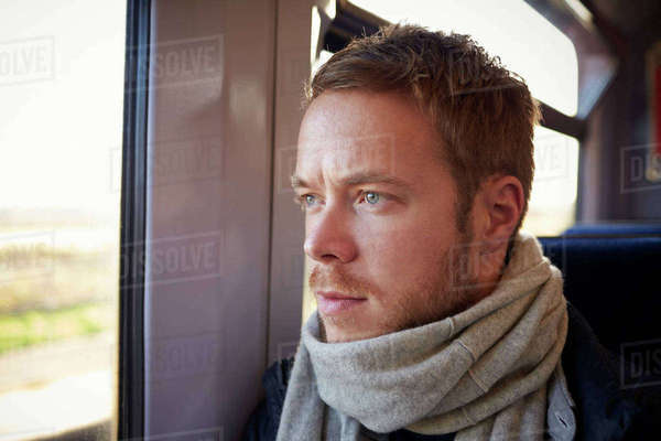Young man sitting in train carriage on railway journey - Stock Photo ...