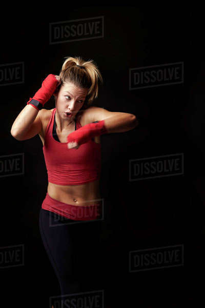 Front view of young woman shadow boxing with fists wrapped - Stock ...