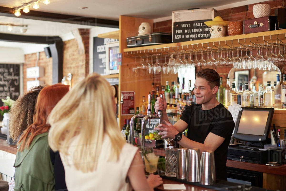 Bartender serving female customers in cocktail bar - Royalty-free Stock ...