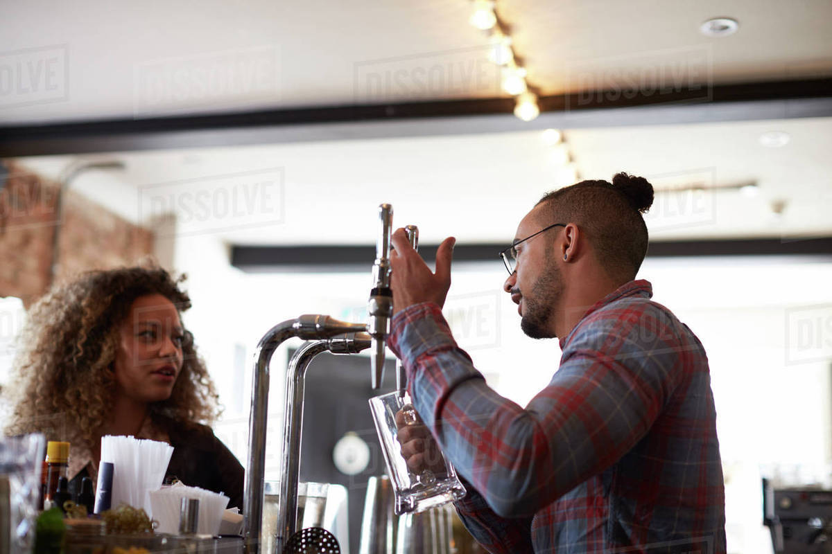 Bartender serving customers in busy bar - Royalty-free Stock Photo ...