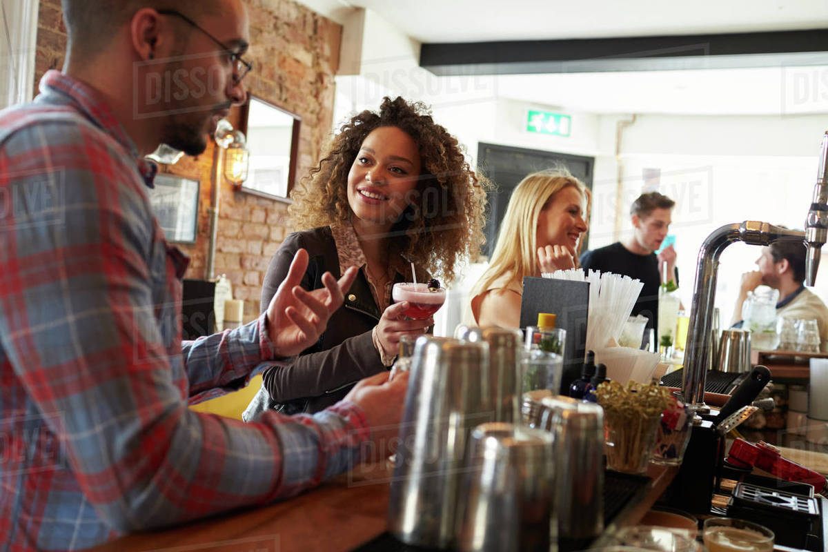 Young couple enjoying drink in busy cocktail bar - Royalty-free Stock ...