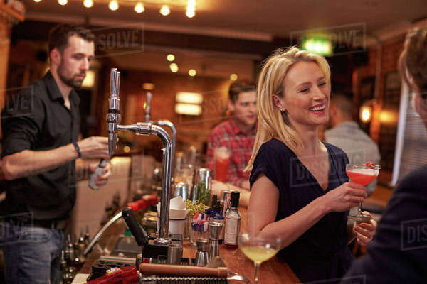 Group of friends meeting for evening drinks in cocktail bar - Royalty ...
