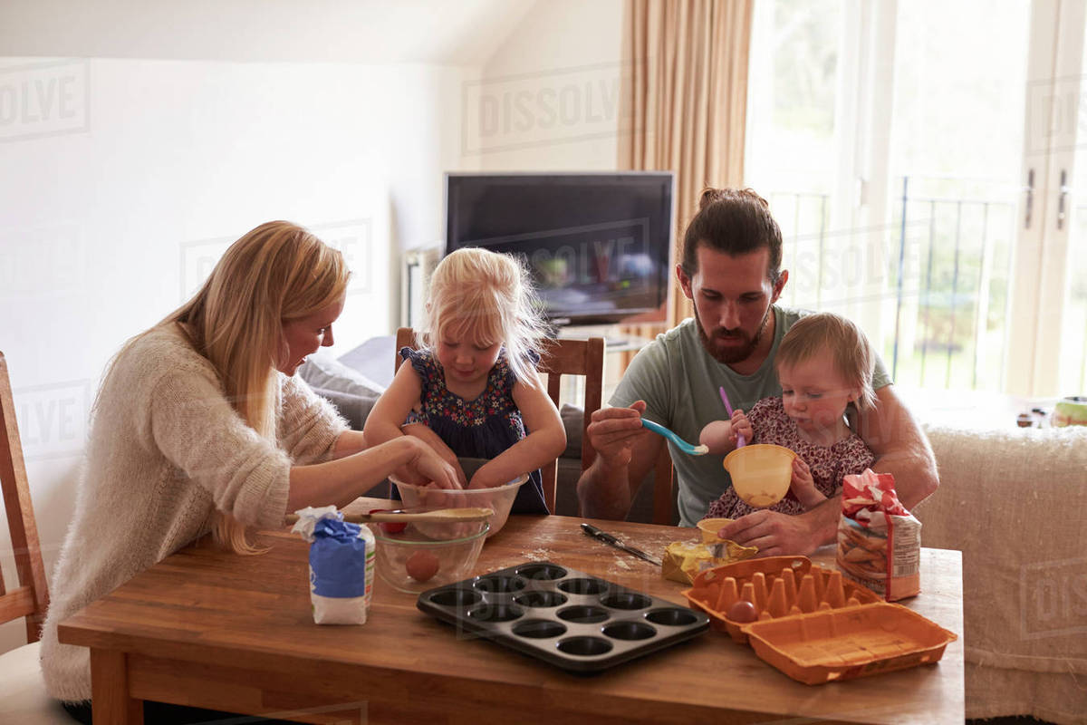 Family at home baking cakes together - Royalty-free Stock Photo | Dissolve
