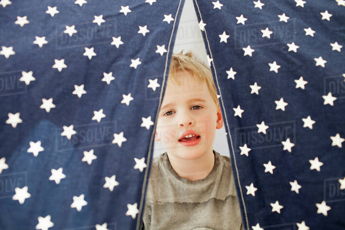Boy playing inside tent at home - Royalty-free Stock Photo | Dissolve