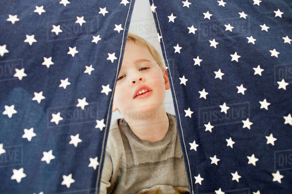 Boy playing inside tent at home - Stock Photo - Dissolve