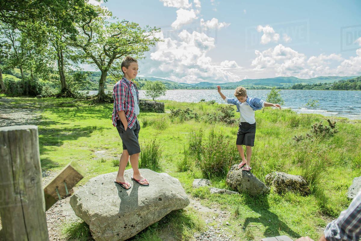 Two boys playing on rocks beside Bala Lake in Wales - Royalty-free ...