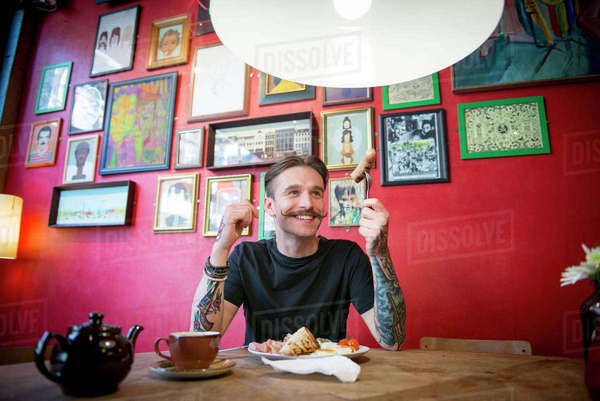 A young man eating at a table in a coffee shop in Manchester - Royalty ...