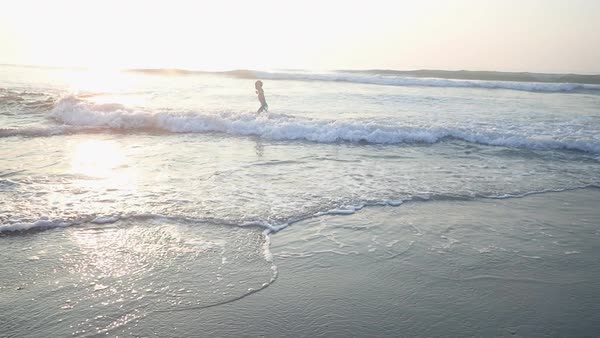 Little boy running in ocean waves at sunrise at Myrtle Beach - Stock ...