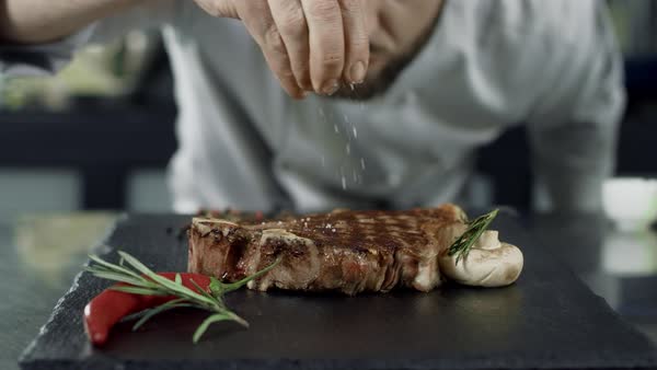 Chef salting a steak - 4K Royalty-free Stock Video Footage | Dissolve