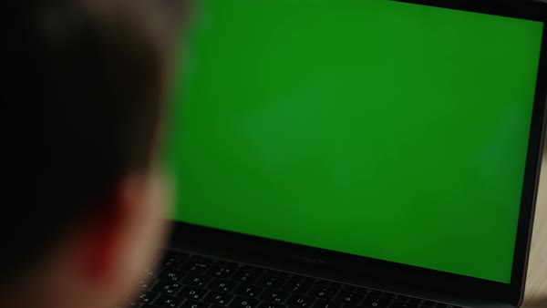 Boy using green screen computer. Schoolboy looking green screen netbook ...