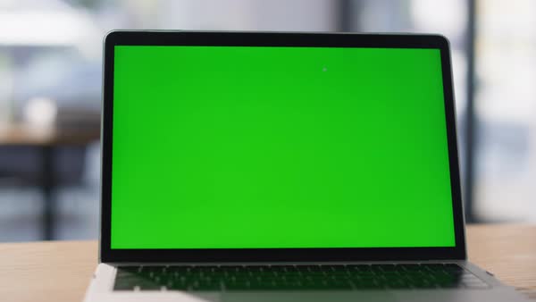 Modern green screen laptop displayed on work desk closeup. Chroma key ...