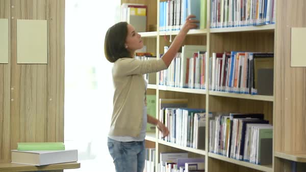 Student girl searching and finding book in school library - HD Royalty ...