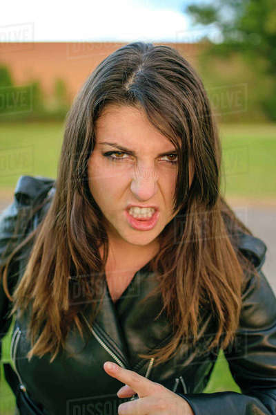 Young sexy woman very angry with aggressive face and pointing with ...