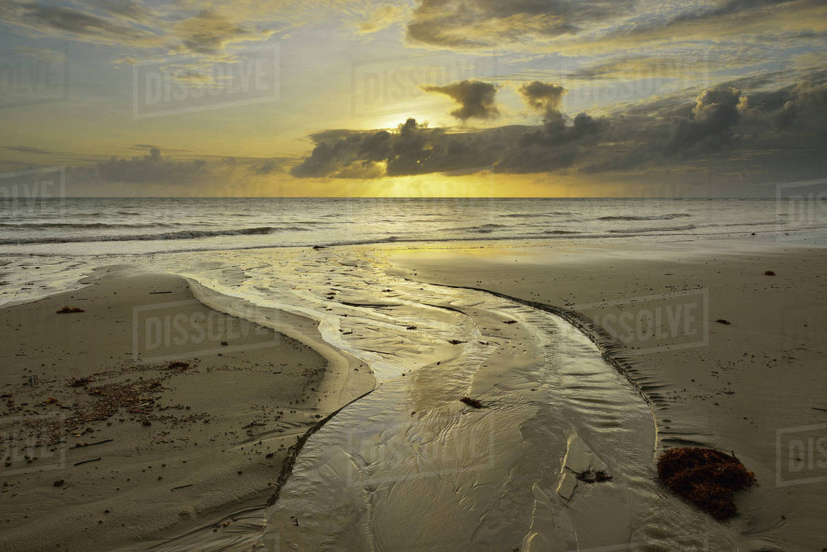Sandy Beach with Tideway Watercourse and Storm Clouds at Sunrise ...