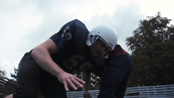 Low-angle side view of two American football players practicing ...