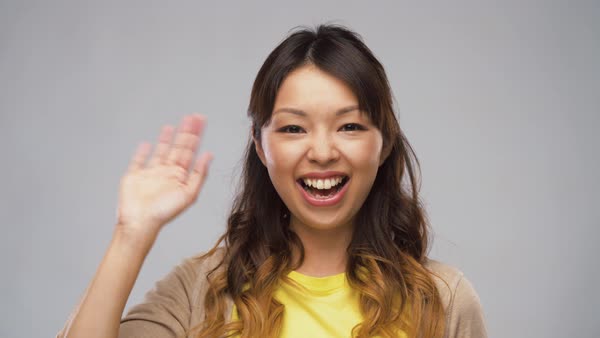 Smiling asian woman waving hand - 4K Royalty-free Stock Video Footage ...
