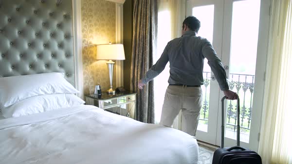Young man walking into a hotel room and falling in bed - 4K Royalty ...