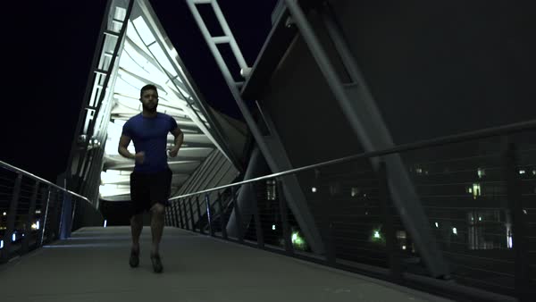 Wide shot of young man running through bridge at night - 4K Royalty ...
