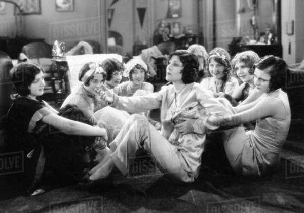Group of young women sitting on the floor of a living room talking ...