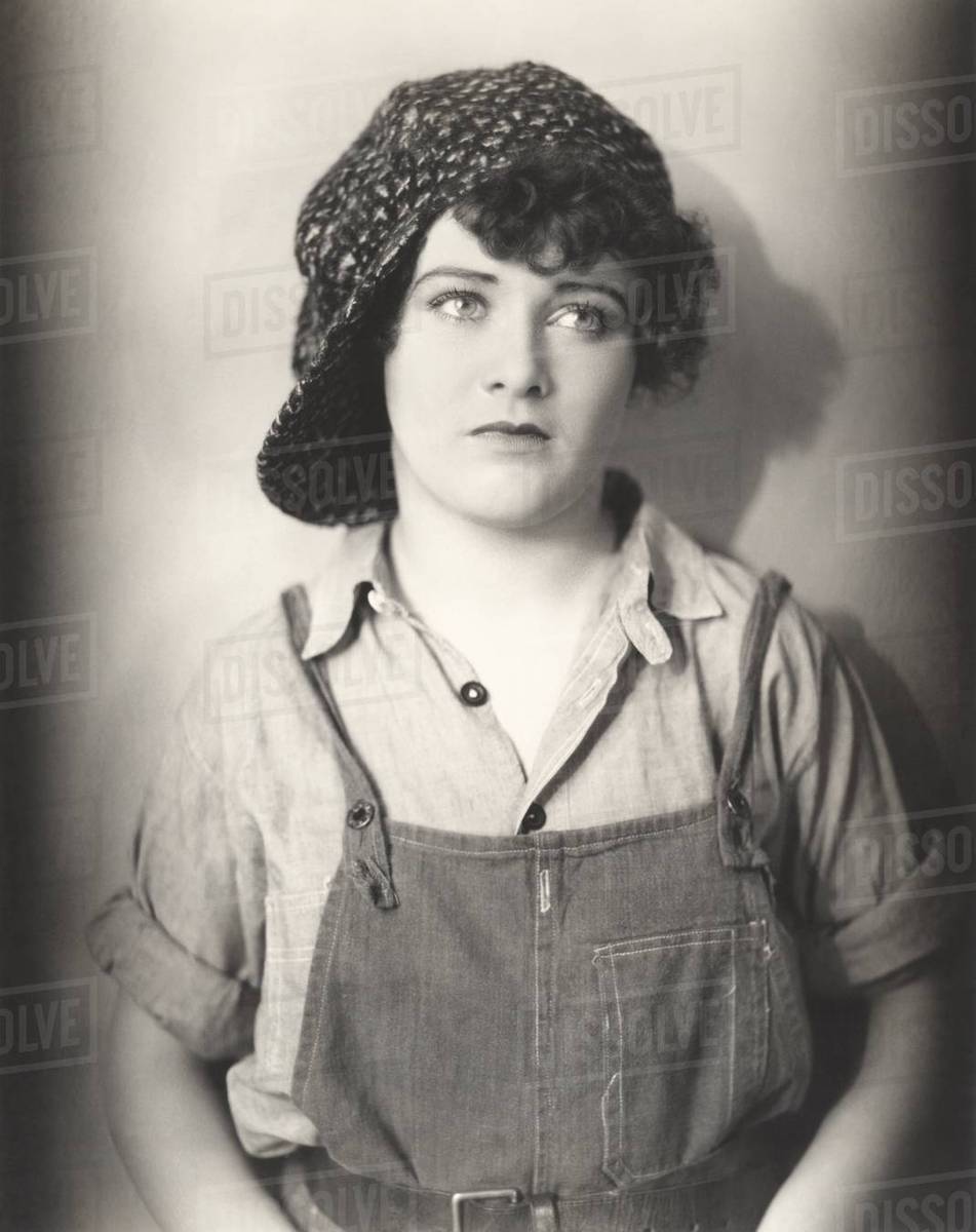 Woman in backwards cap and bib overalls - Stock Photo - Dissolve