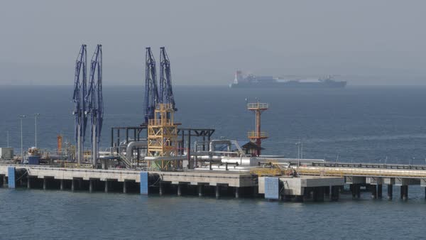 Liquefied gas terminal with large LNG carrier on horizon of sea - Stock ...