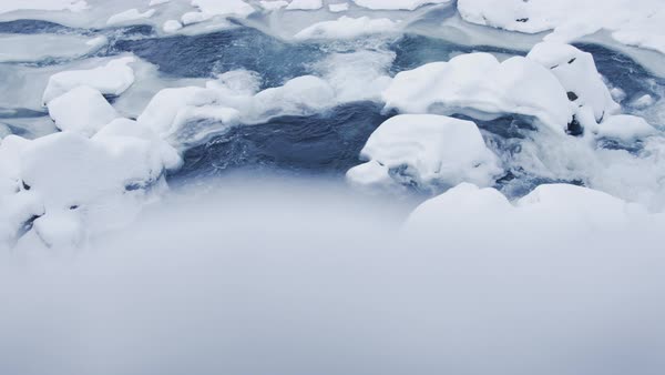 Churning river water in an icy Icelandic environment, slow motion ...