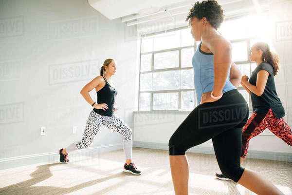 Instructor leading students in exercise class in studio - Royalty-free ...