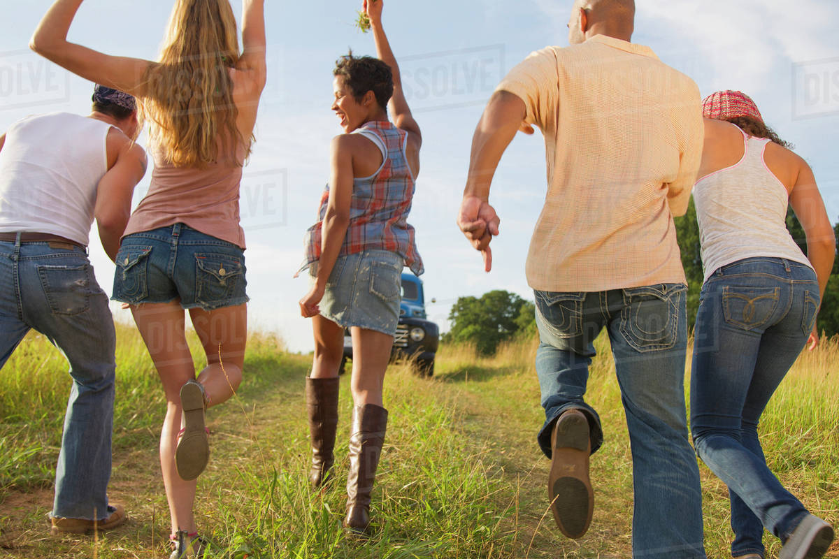 Happy friends running together in field - Royalty-free Stock Photo ...